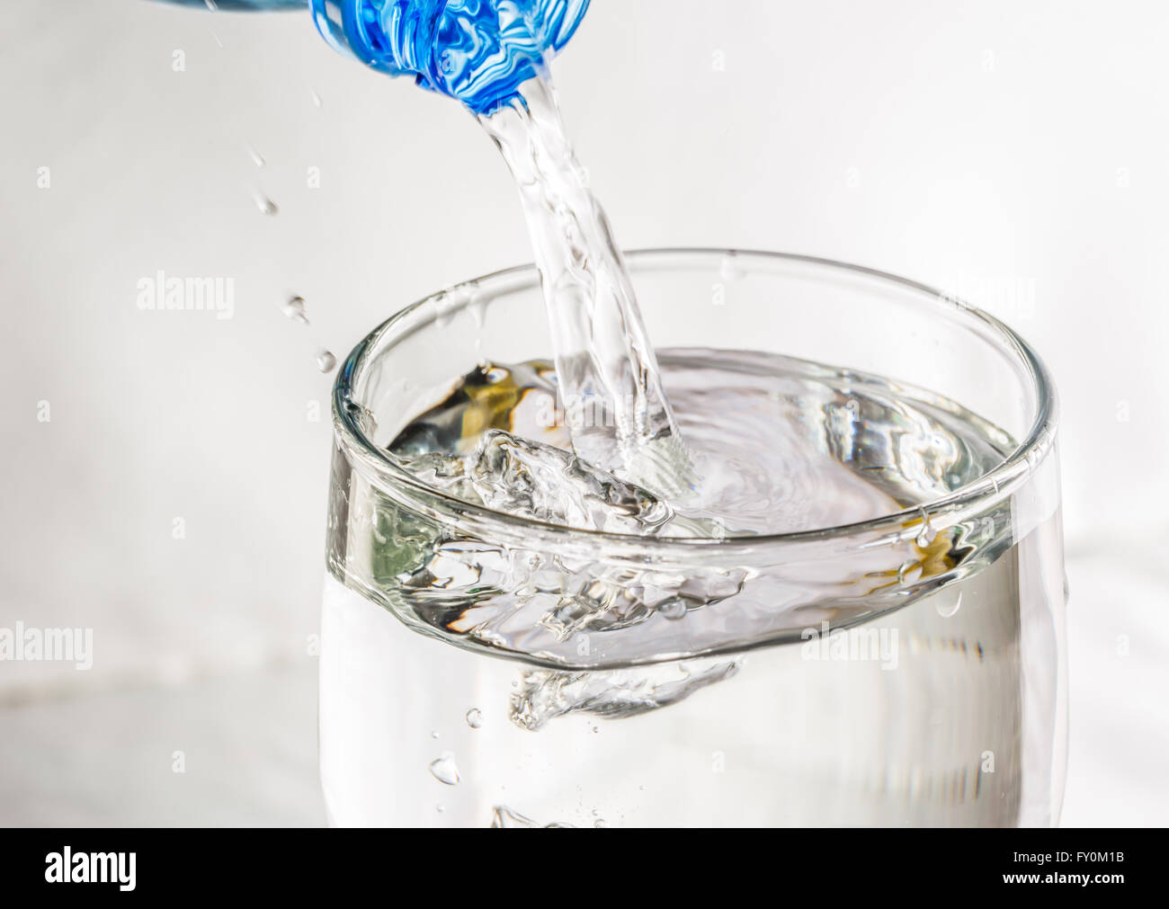 Pouring water from bottle into glass Stock Photo - Alamy