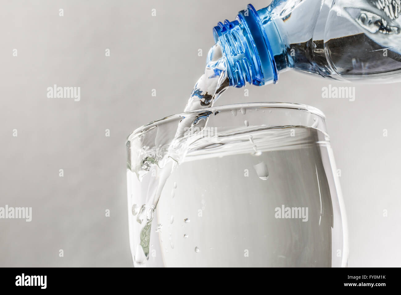 Pouring water from bottle into glass Stock Photo - Alamy