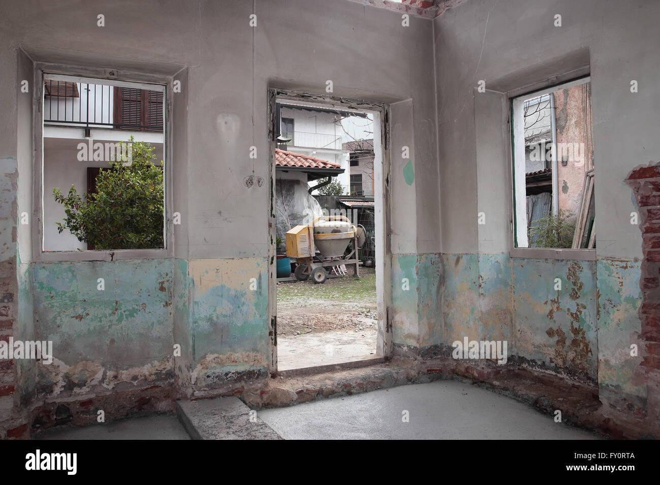 House under construction, empty interior with cement mixer machine ...