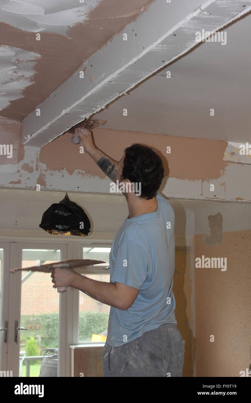 A plasterer plastering a room after walls have been knocked down Stock ...