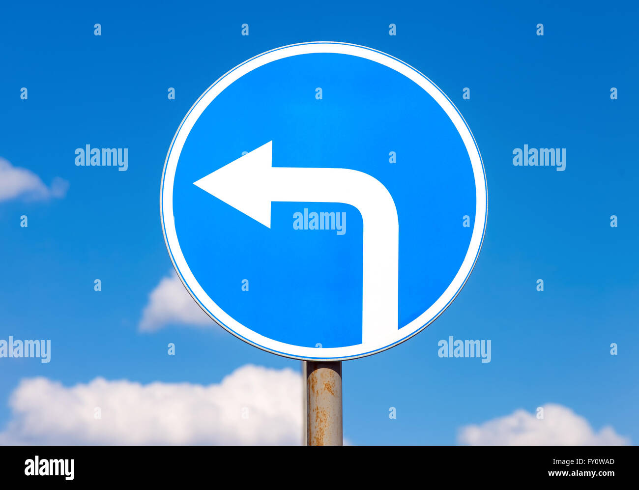 Road sign Turn left against the blue sky Stock Photo - Alamy