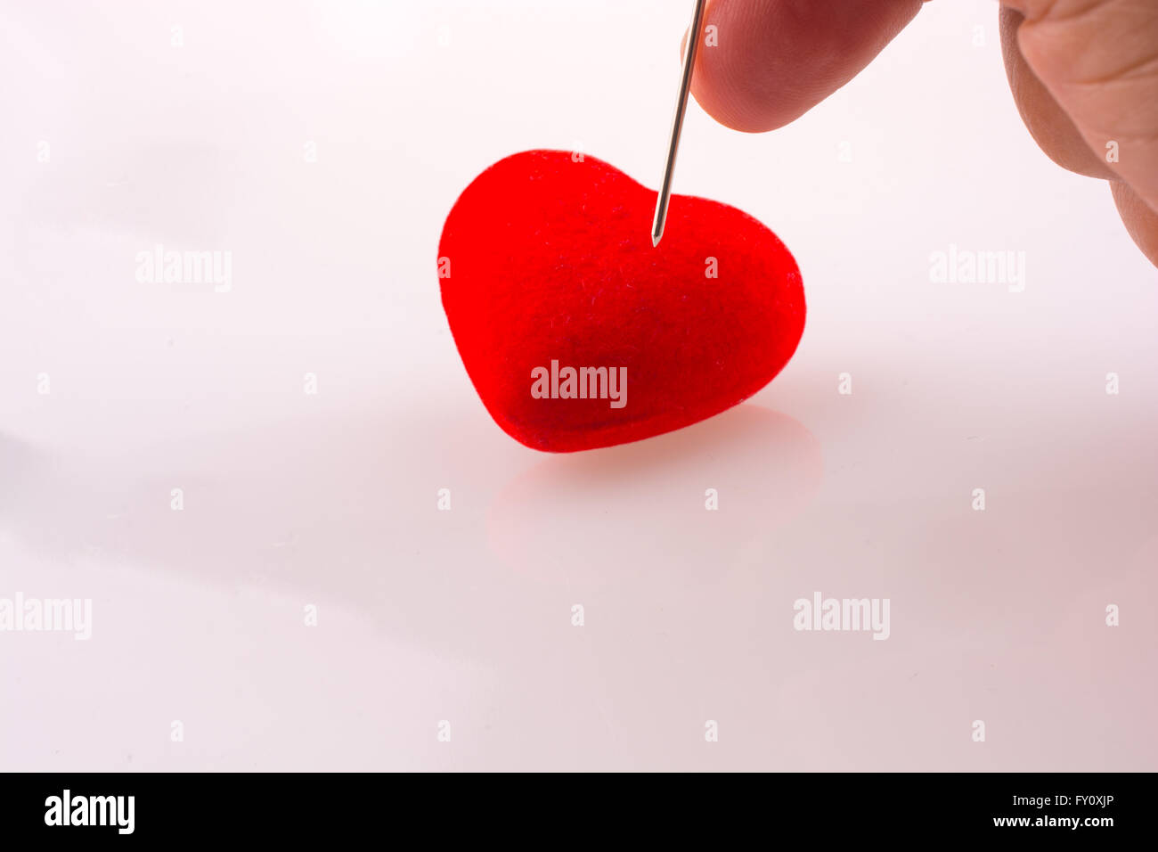 Hand pointing a needle on a heart Stock Photo - Alamy