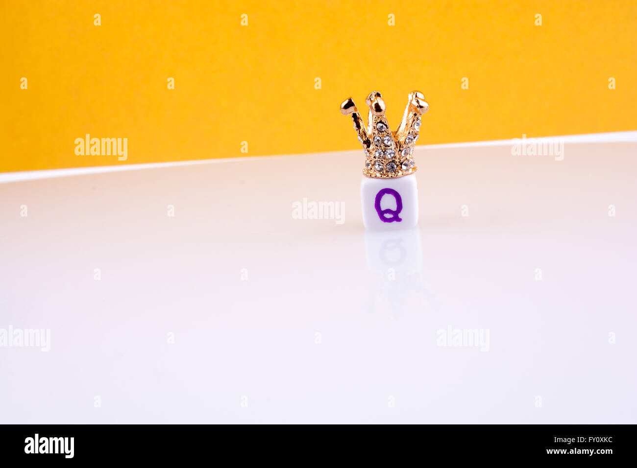Crown on letter cube on a yellow and white background Stock Photo - Alamy