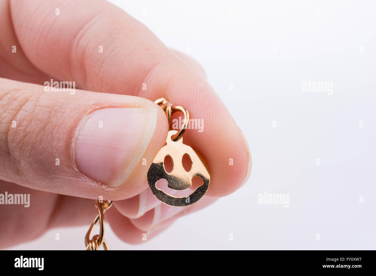 Golden color smileys arrayed on a chain in hand Stock Photo - Alamy
