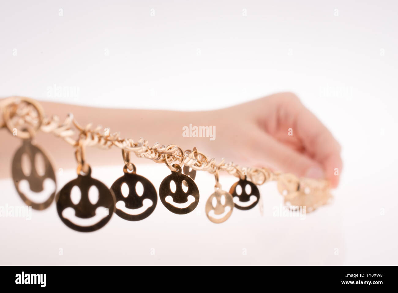 Golden color smileys arrayed on a chain in hand Stock Photo - Alamy