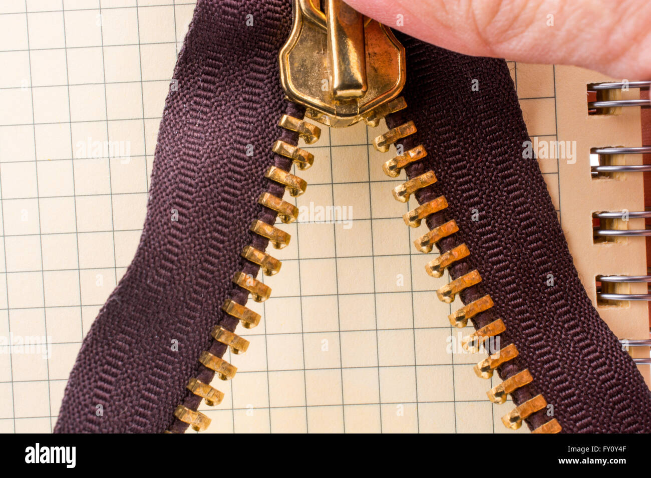 Spiral notebook through a zipper on a white background Stock Photo - Alamy