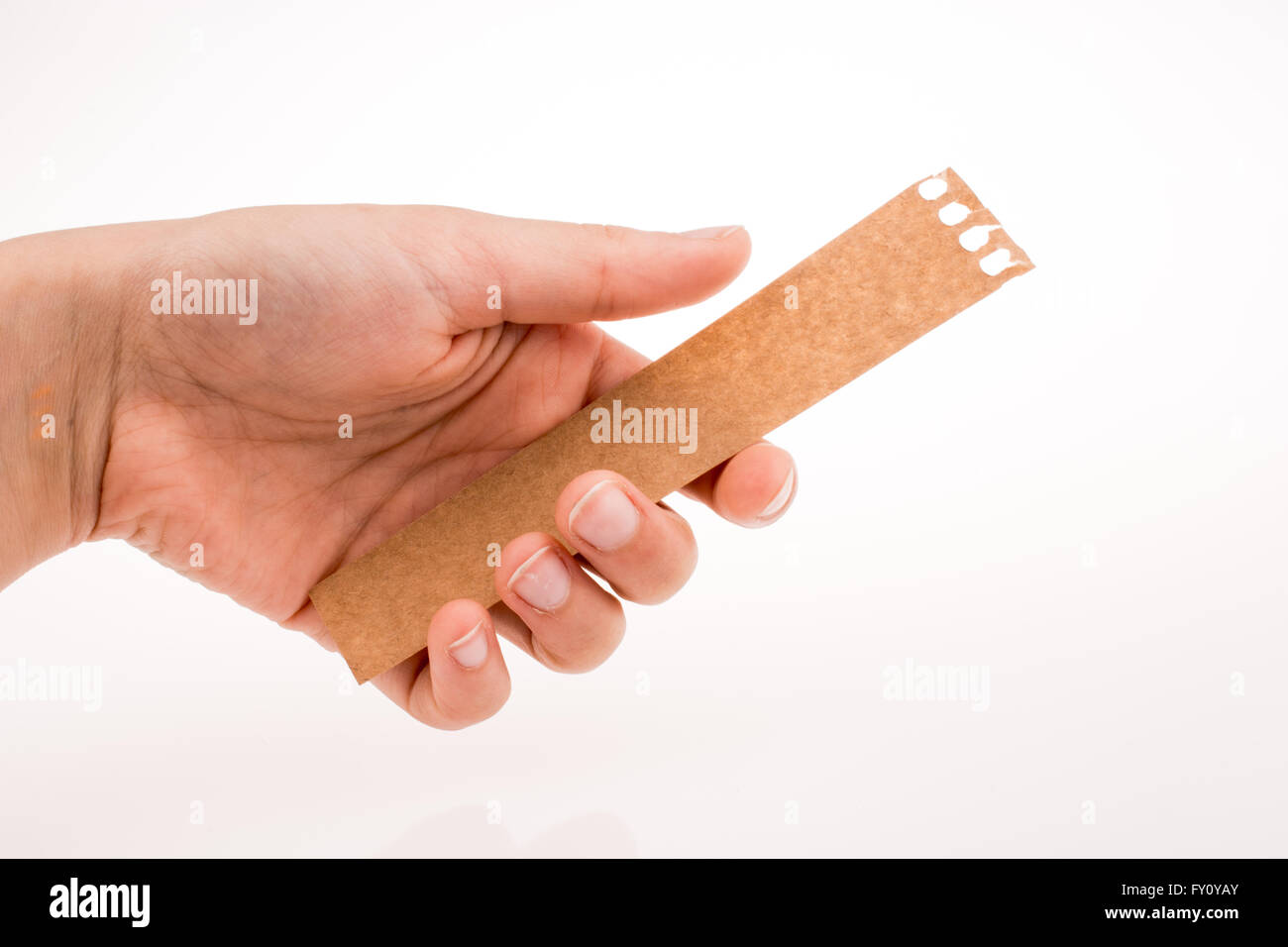 Hand holding a piece of paper on a white background Stock Photo - Alamy