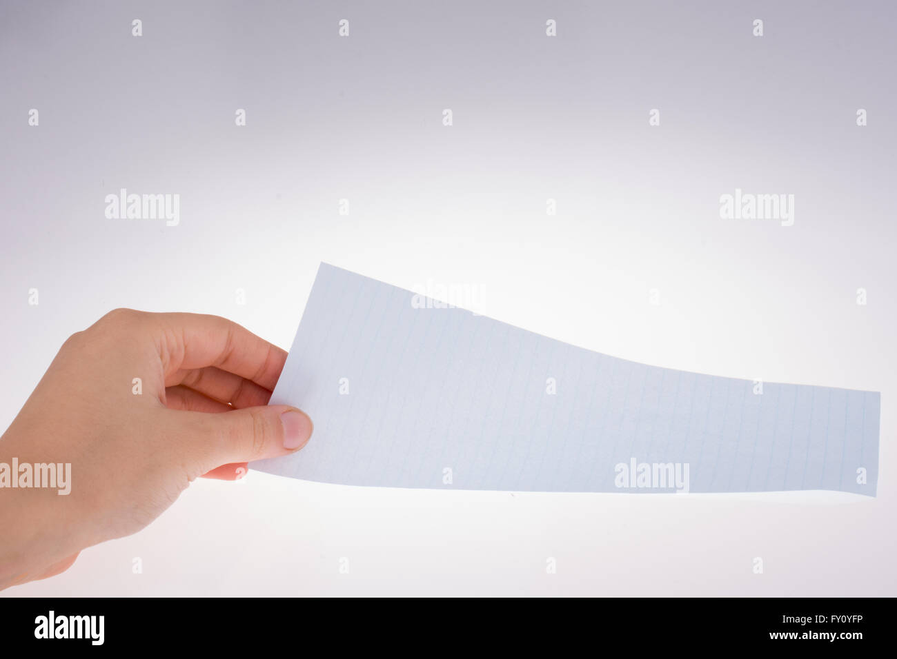 Hand holding a piece of paper on a white background Stock Photo - Alamy