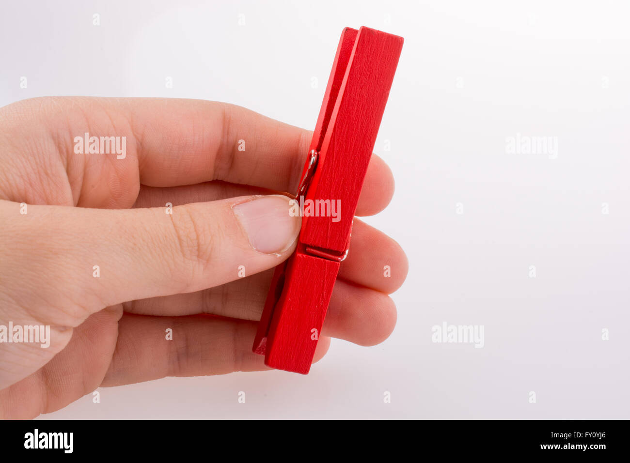 Hand holding a red clothespin on a white background Stock Photo - Alamy