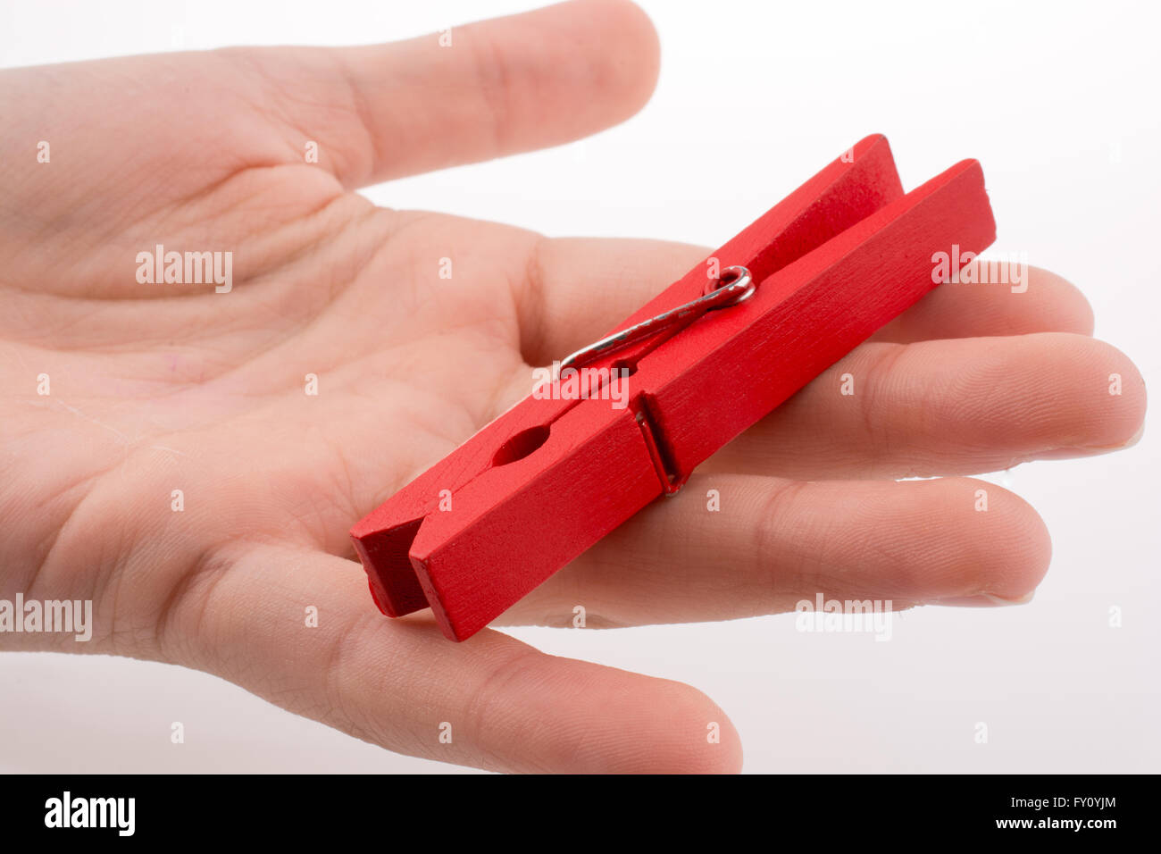 Hand holding a red clothespin on a white background Stock Photo - Alamy