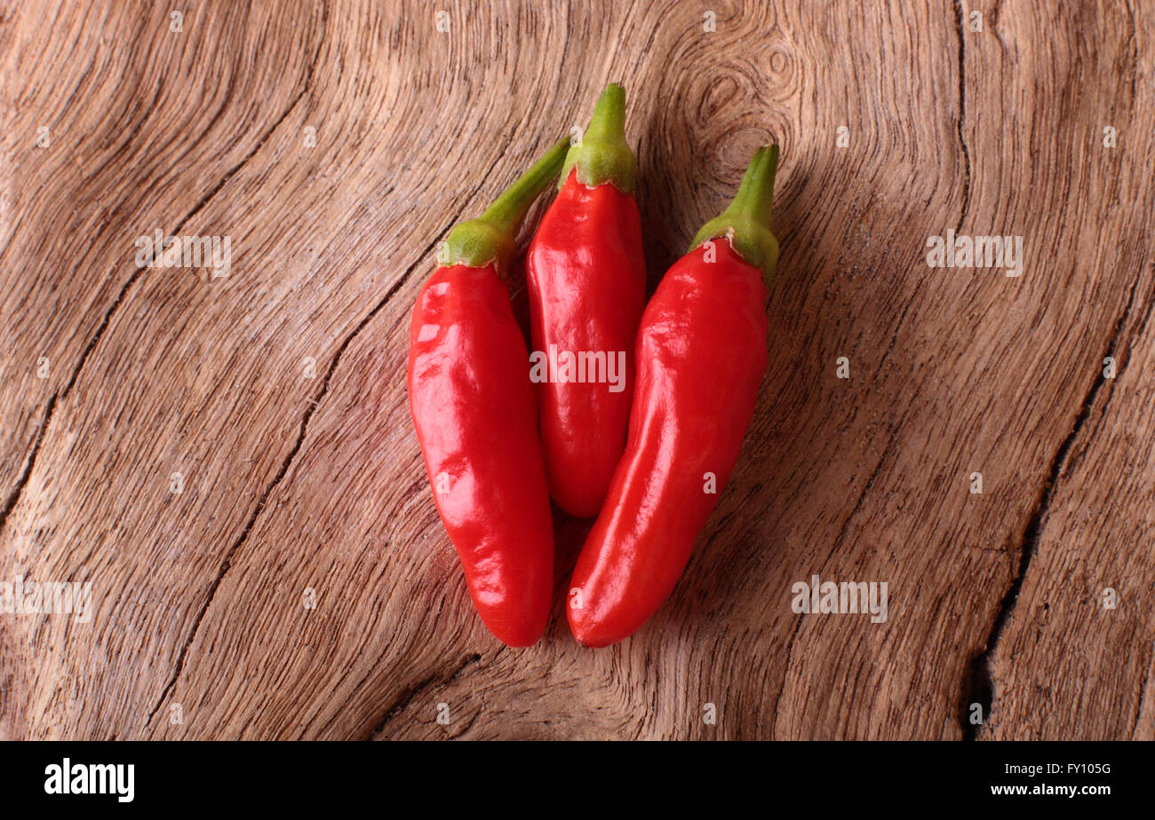 Three Red piri piri chili peppers on a rustic timber background Stock ...