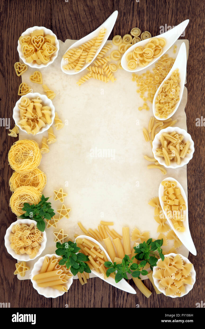 Italian pasta selection and basil herb forming an abstract border over ...