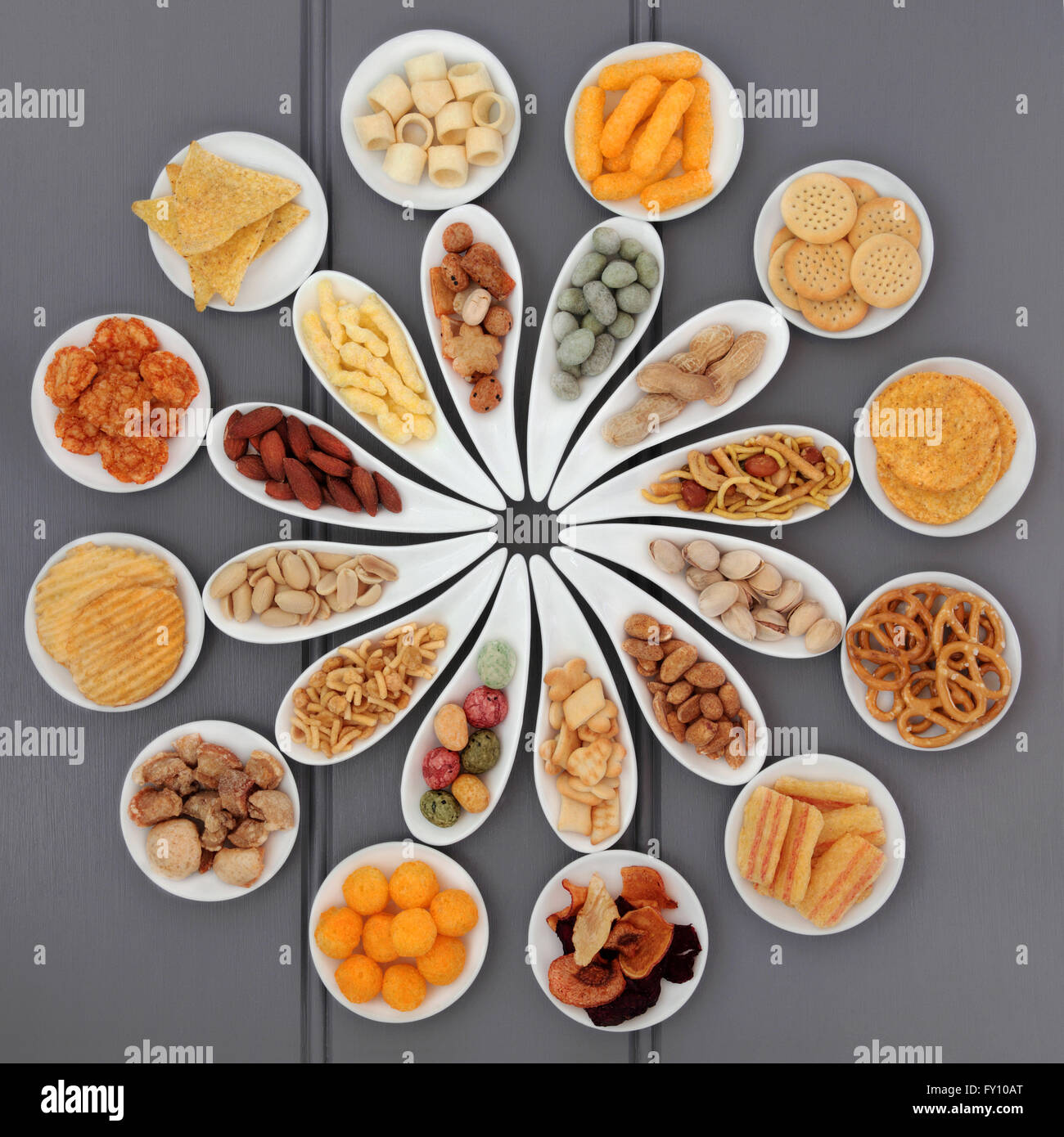 Large savoury snack selection in porcelain dishes over grey wooden ...