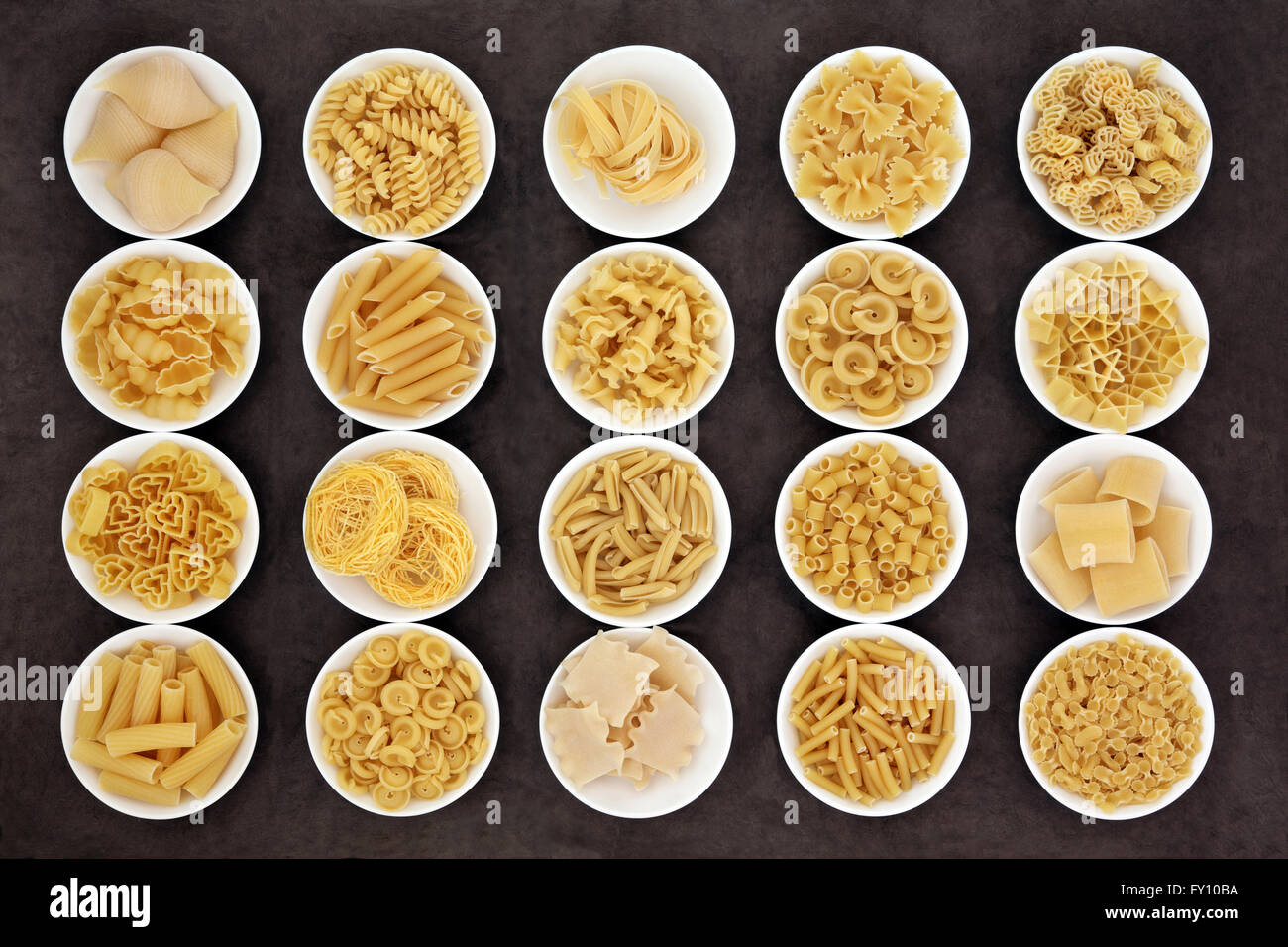 Large pasta dried food selection in round bowls over brown background ...