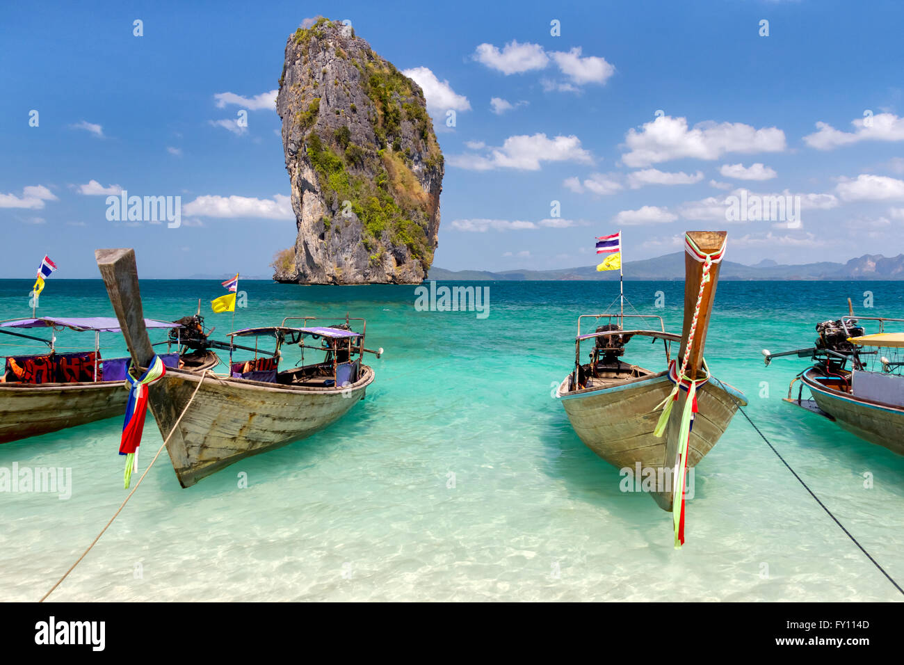 Boats stand at the shore on a tropical beach against the backdrop of ...