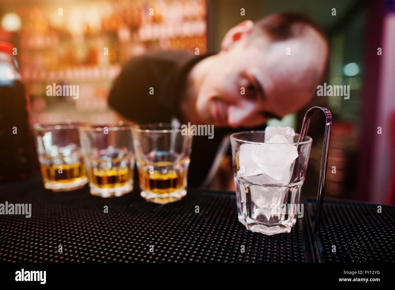 Glass with ice and tongs with three whiskey glasses background funny ...