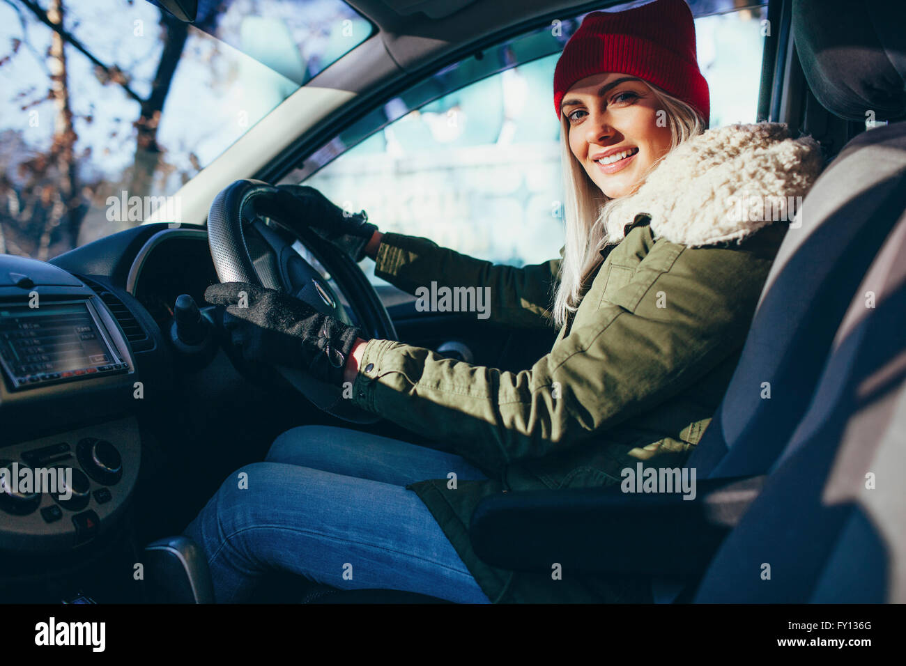 Portrait of happy young woman in warm clothing driving car Stock Photo ...