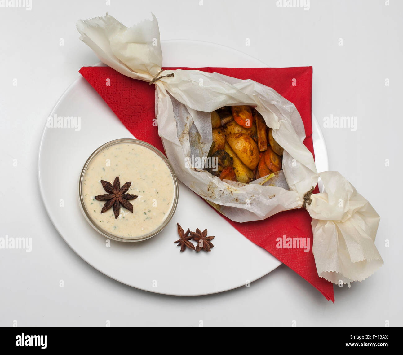 Roasted potatoes and root vegetables by sauce in plate Stock Photo - Alamy