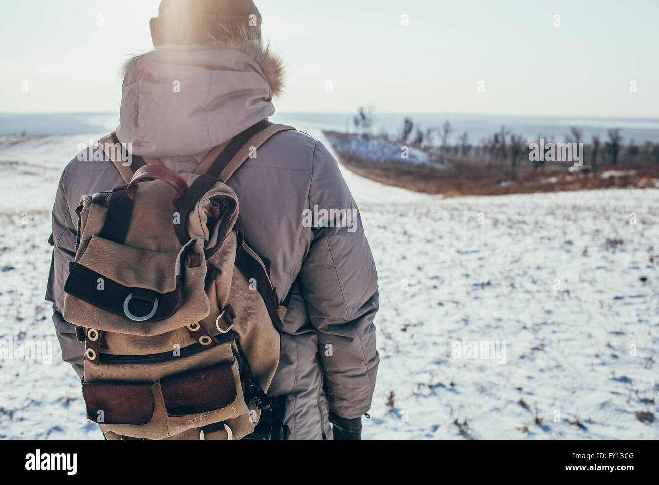 Rear view of hiker standing on snow covered landscape Stock Photo - Alamy