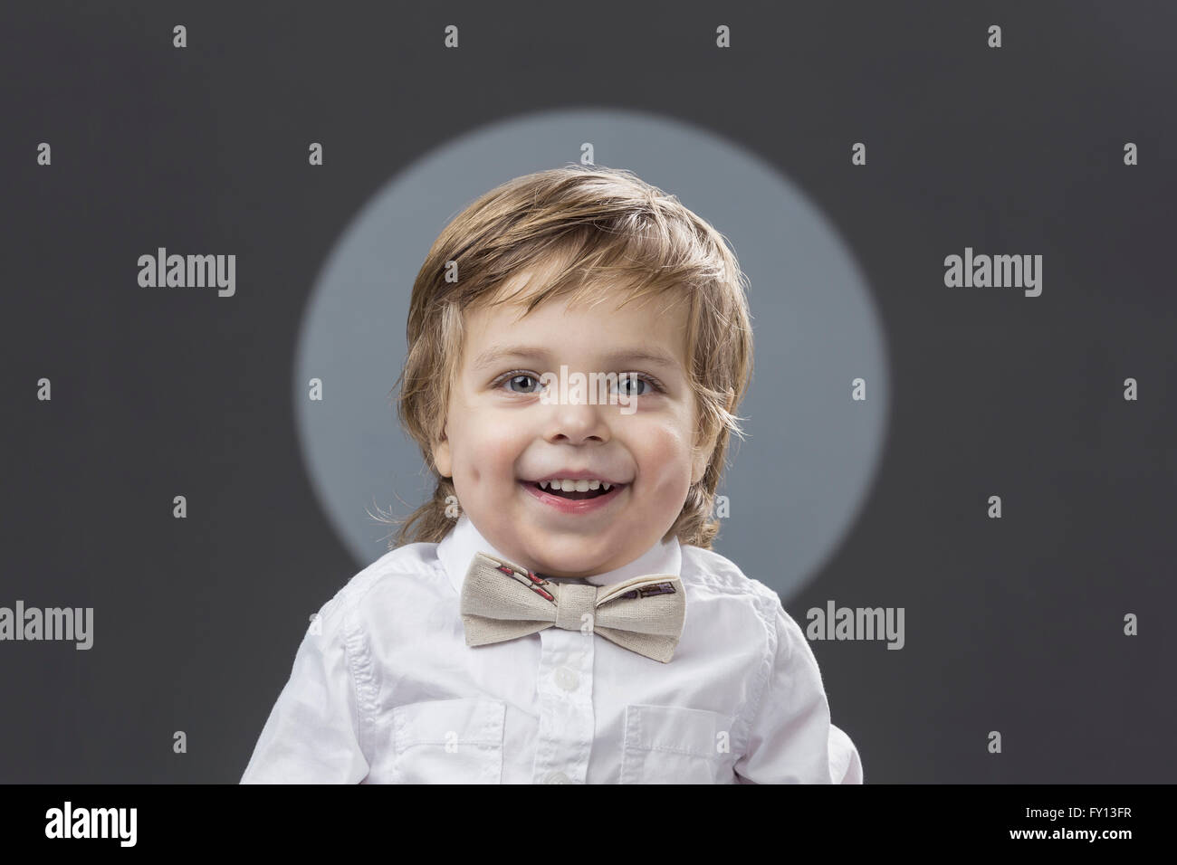Portrait of cute boy with bowtie against gray background Stock Photo ...