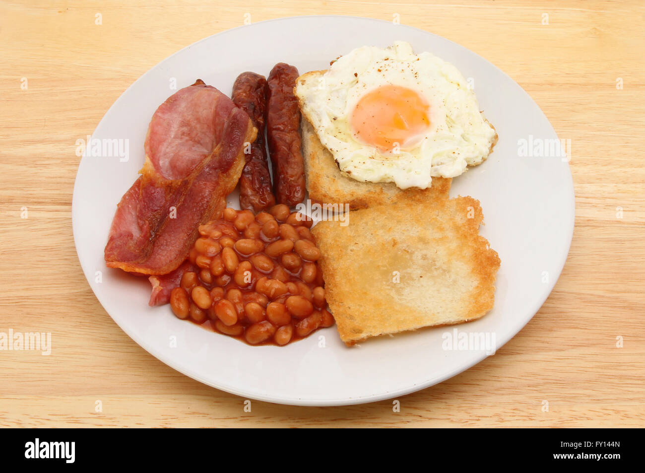 Cooked English breakfast on a plate on a wooden tabletop Stock Photo ...