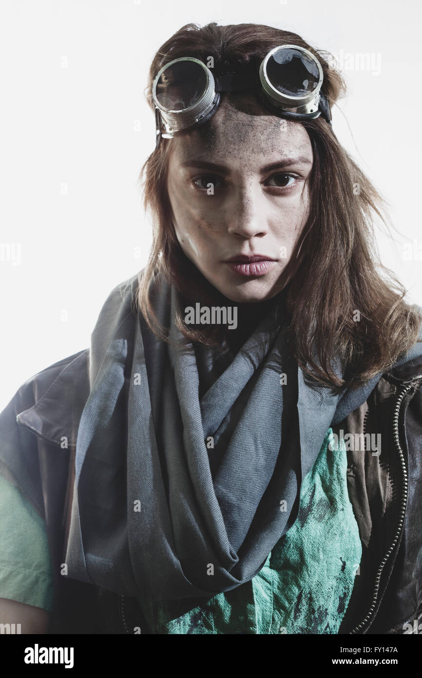 Portrait of young woman wearing goggles and jacket against white ...