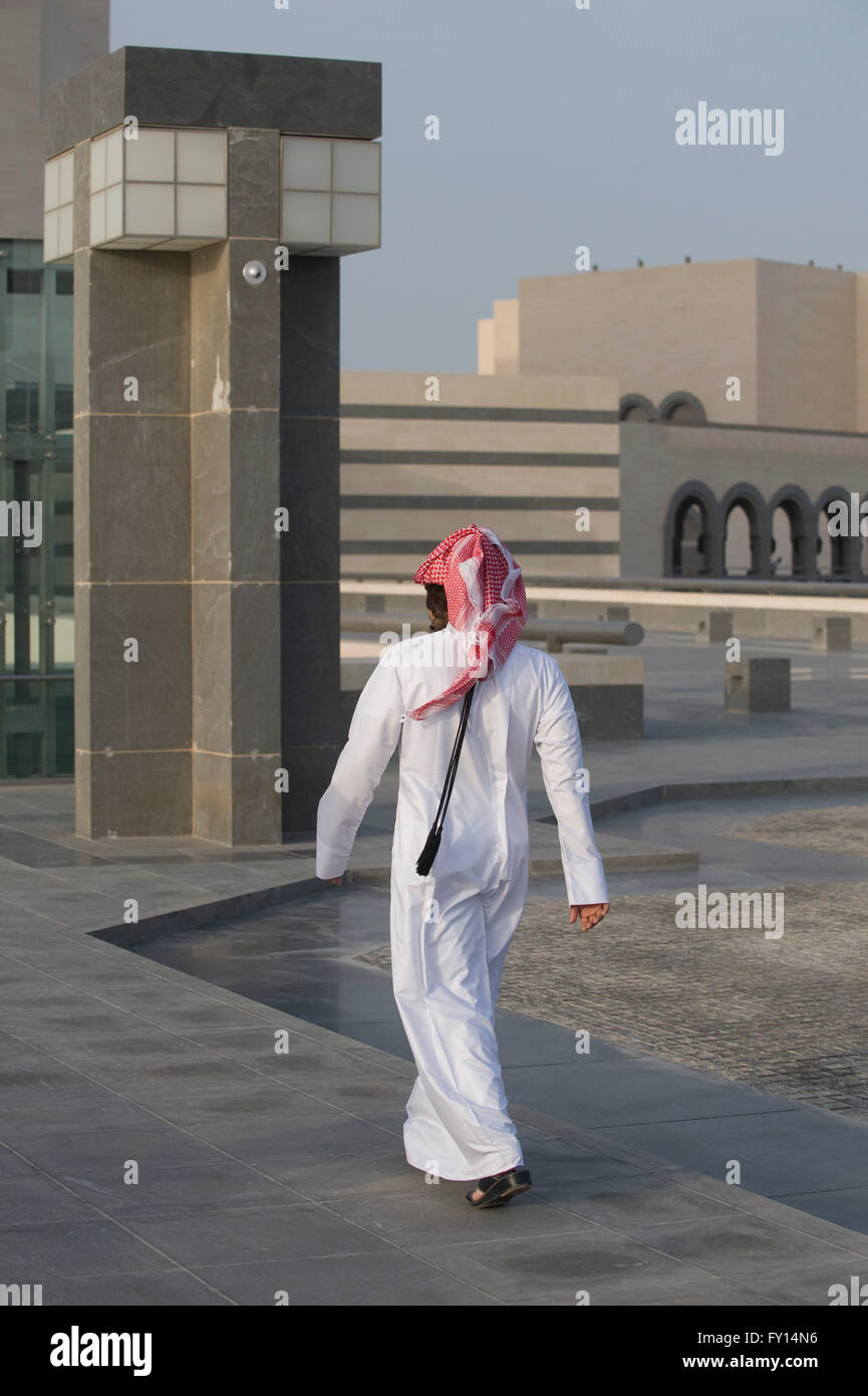Rear view of Arab man walking on floor against buildings Stock Photo ...