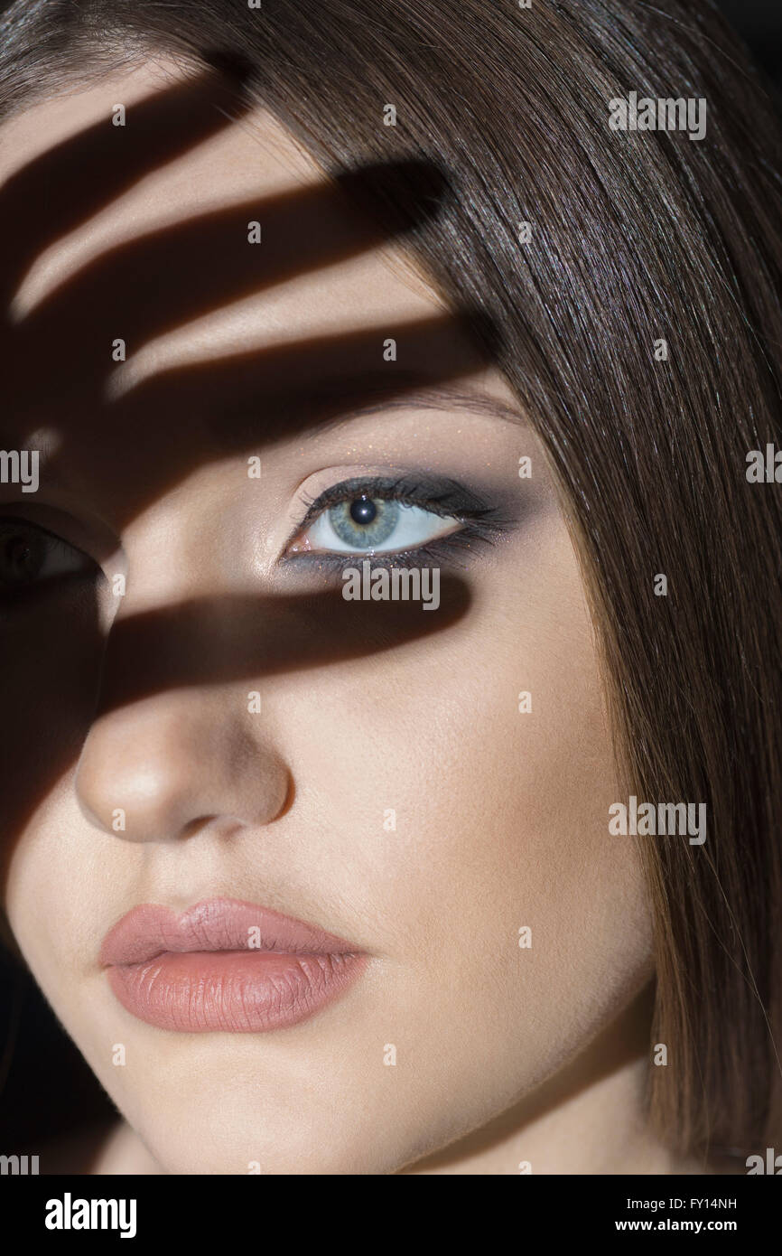 Close-up of hand shadow on woman's face Stock Photo - Alamy