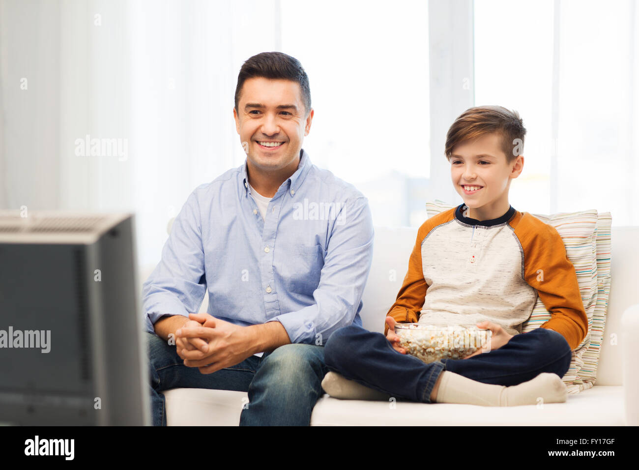 smiling father and son watching tv at home Stock Photo - Alamy