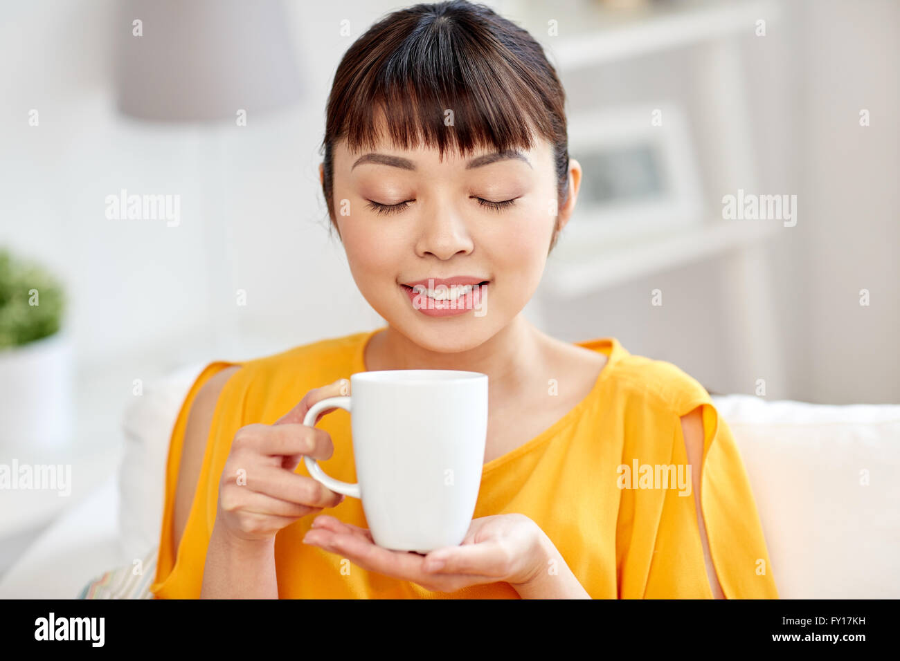happy asian woman drinking from tea cup Stock Photo - Alamy