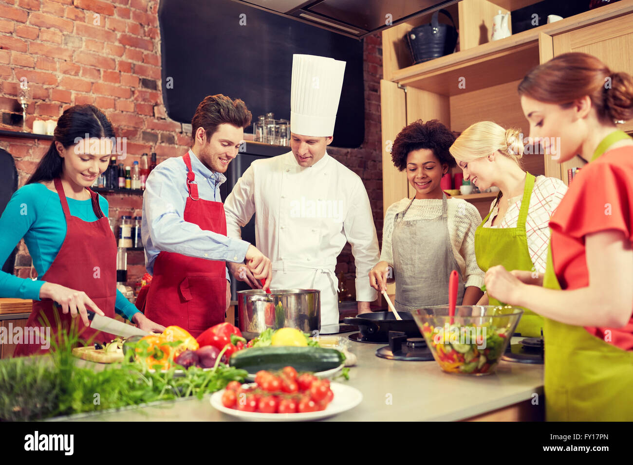 happy friends and chef cook cooking in kitchen Stock Photo - Alamy