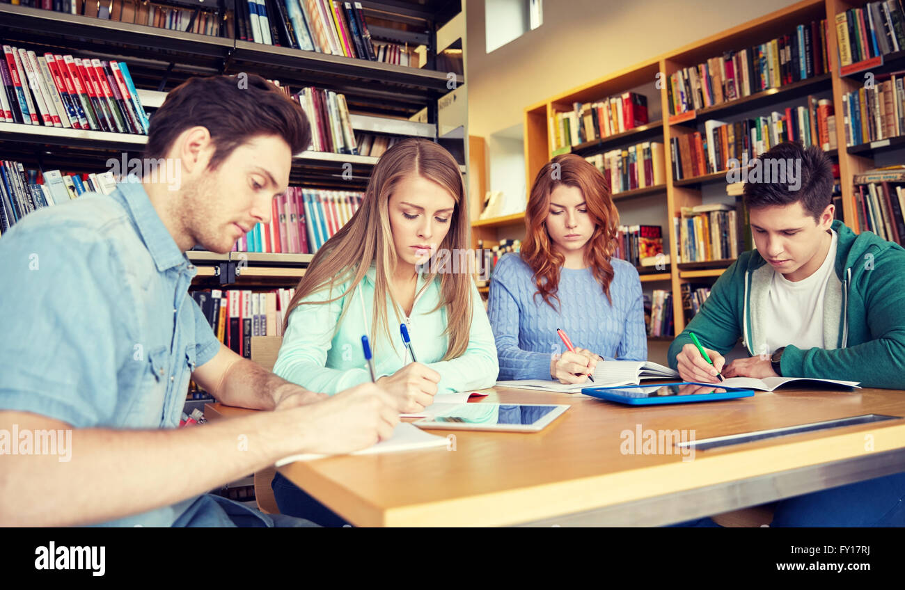 happy students writing to notebooks in library Stock Photo - Alamy