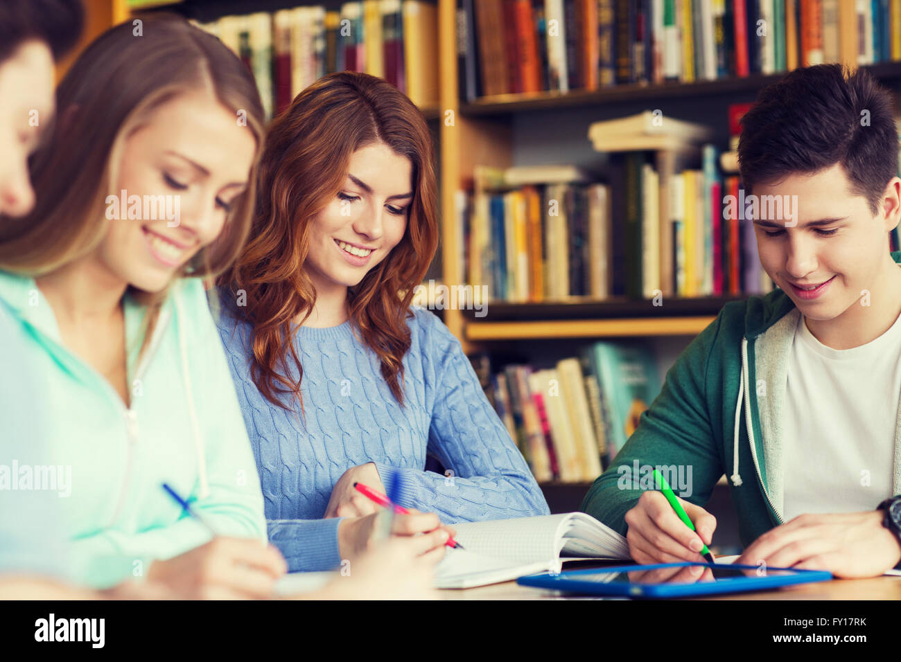 happy students writing to notebooks in library Stock Photo - Alamy