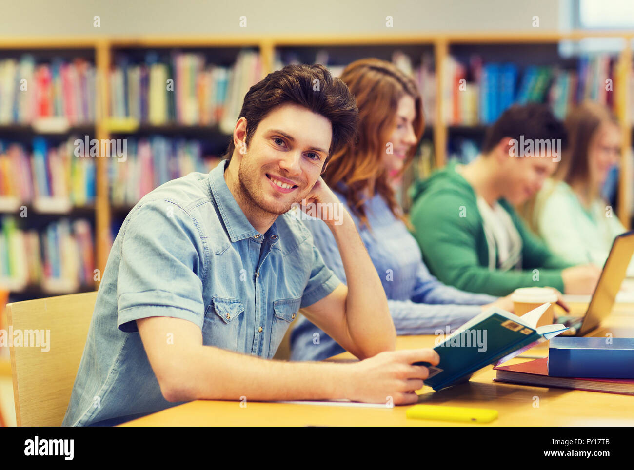 happy student boy reading book in library Stock Photo - Alamy