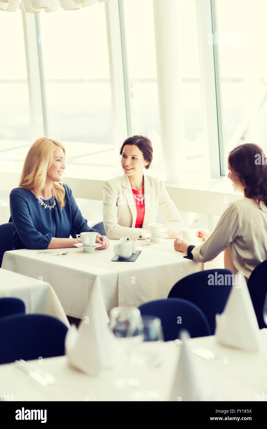 women drinking coffee and talking at restaurant Stock Photo - Alamy