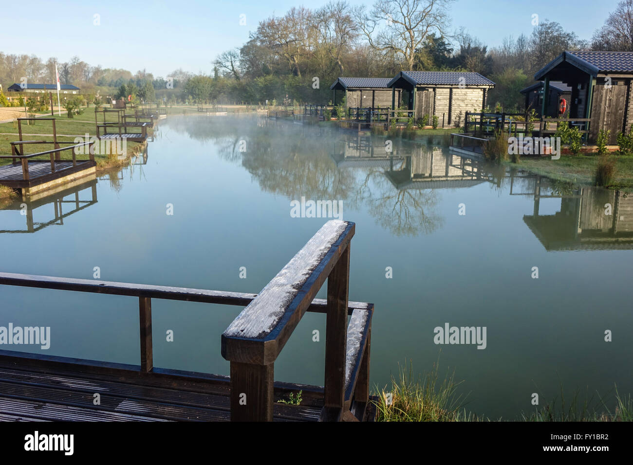Henlow, Bedfordshire, UK. Wooden pontoon over a small fishing lake with ...