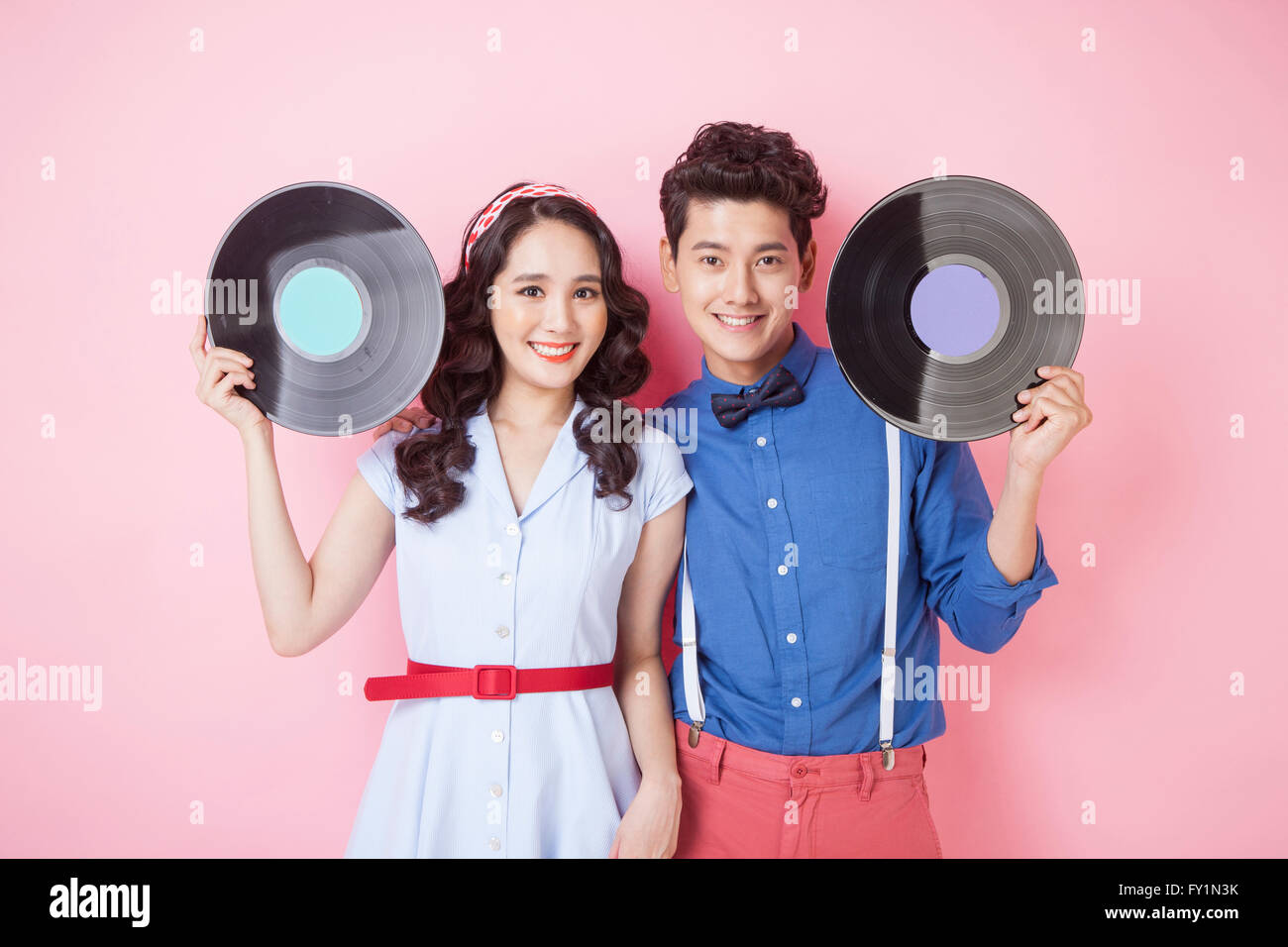 Portrait of young smiling couple holding records staring at front Stock ...