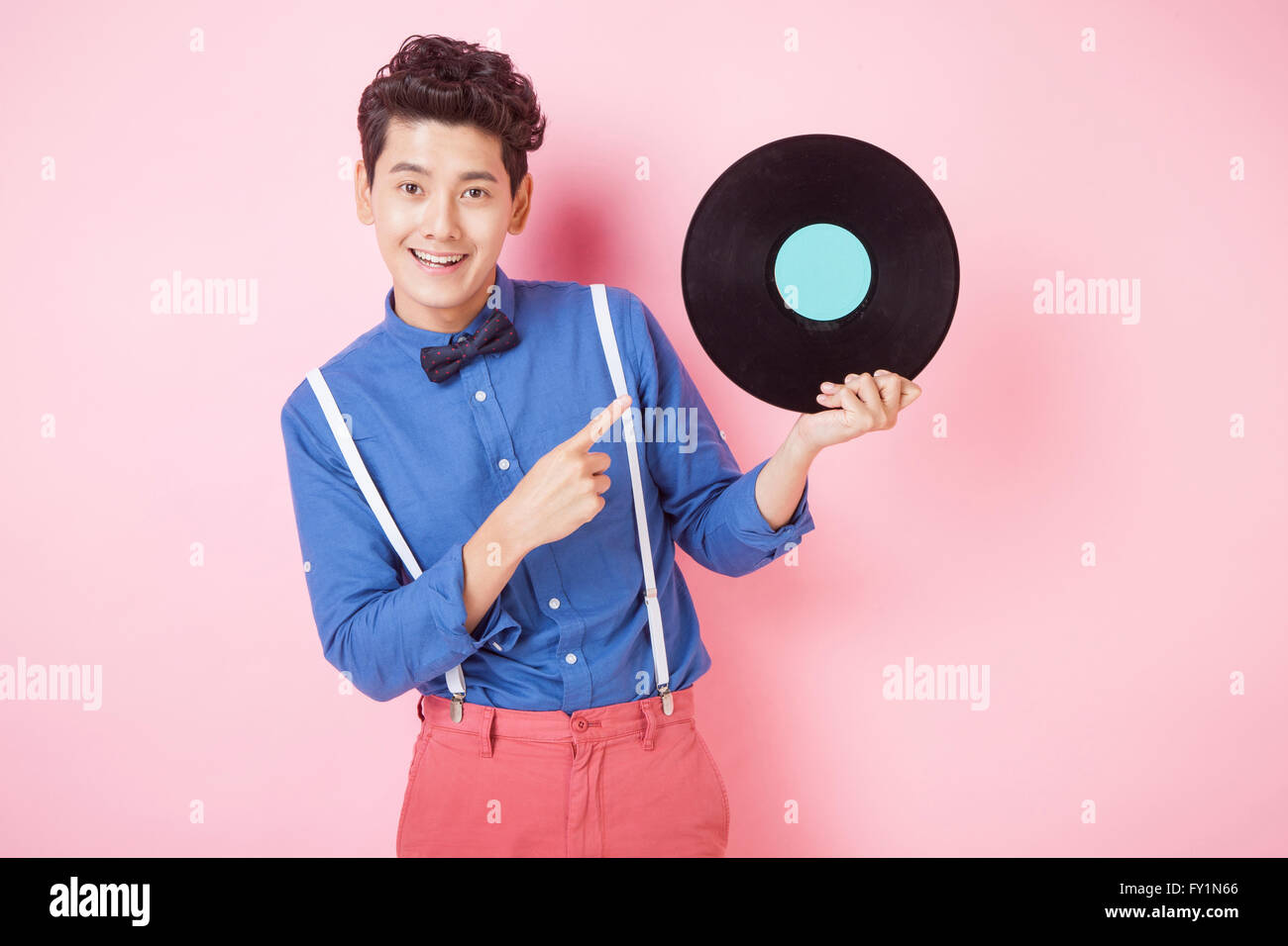 Portrait of young smiling man in retro style holding and pointing to a ...