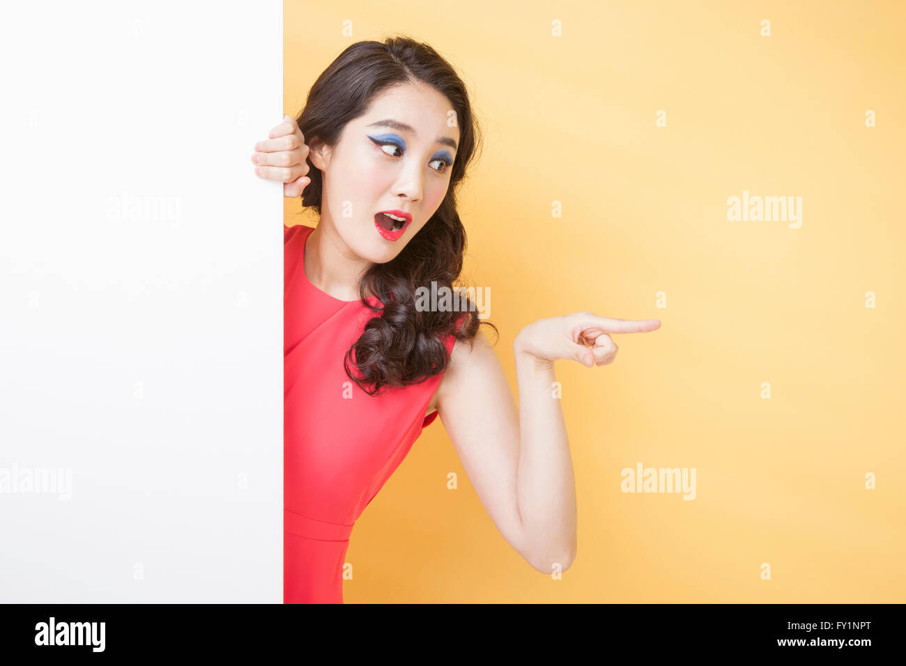Portrait of young woman in retro style pointing and looking aside with ...