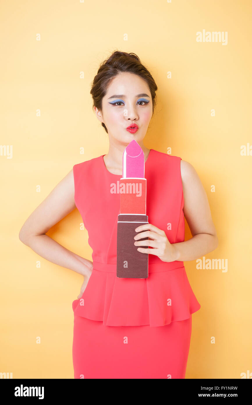 Young smiling woman in retro style posing with a lipstick staring at ...