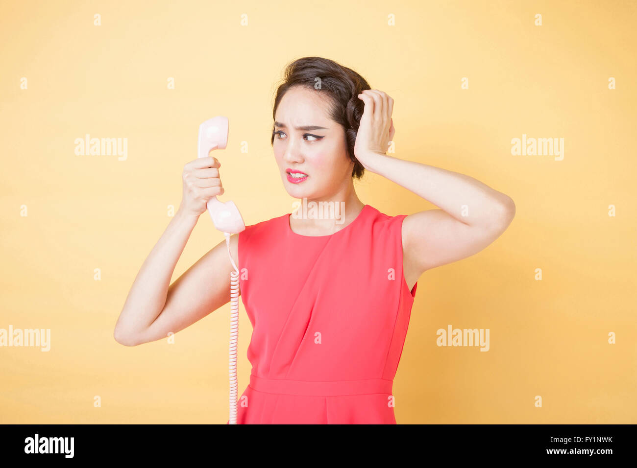 Side view portrait of young woman in retro style holding a phone with a ...