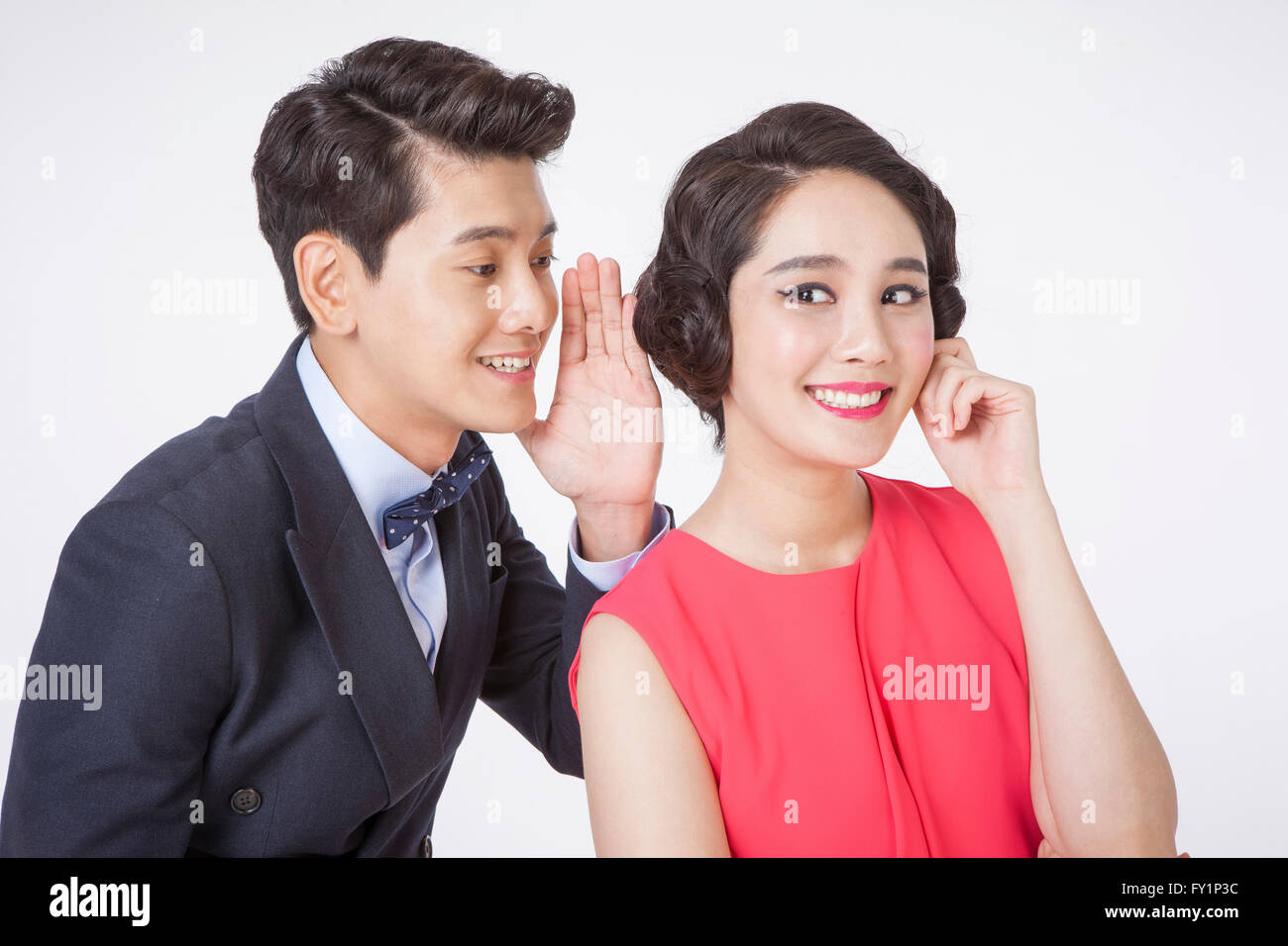 Portrait of young couple talking in a whisper Stock Photo - Alamy