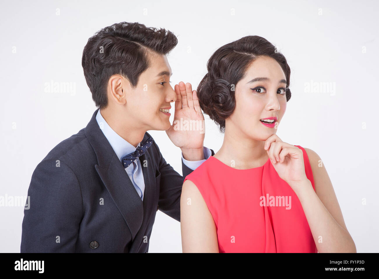 Portrait of young couple in retro styles talking in a whisper Stock ...