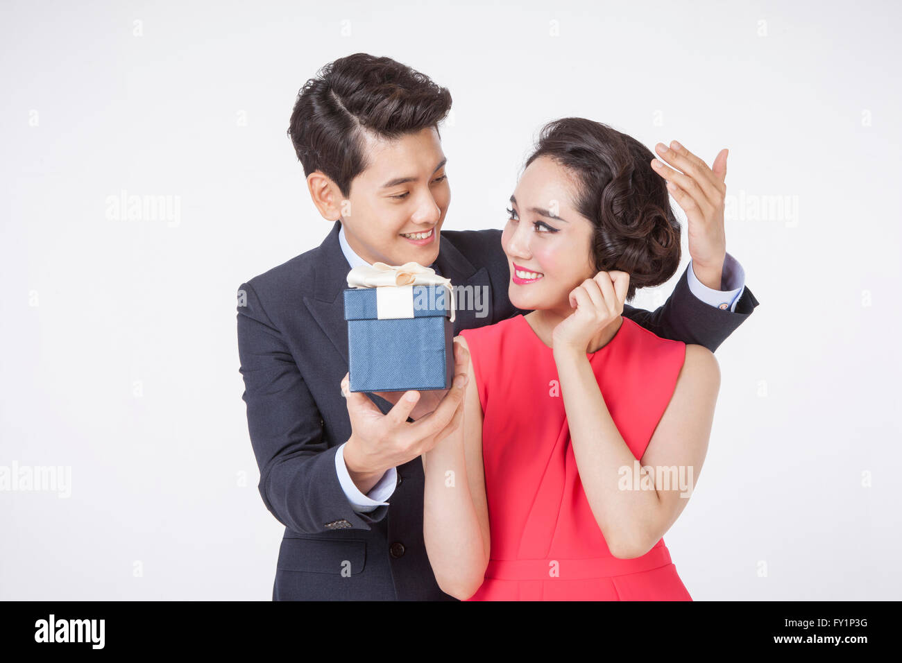Portrait of young smiling man showing a gift box to young smiling woman ...