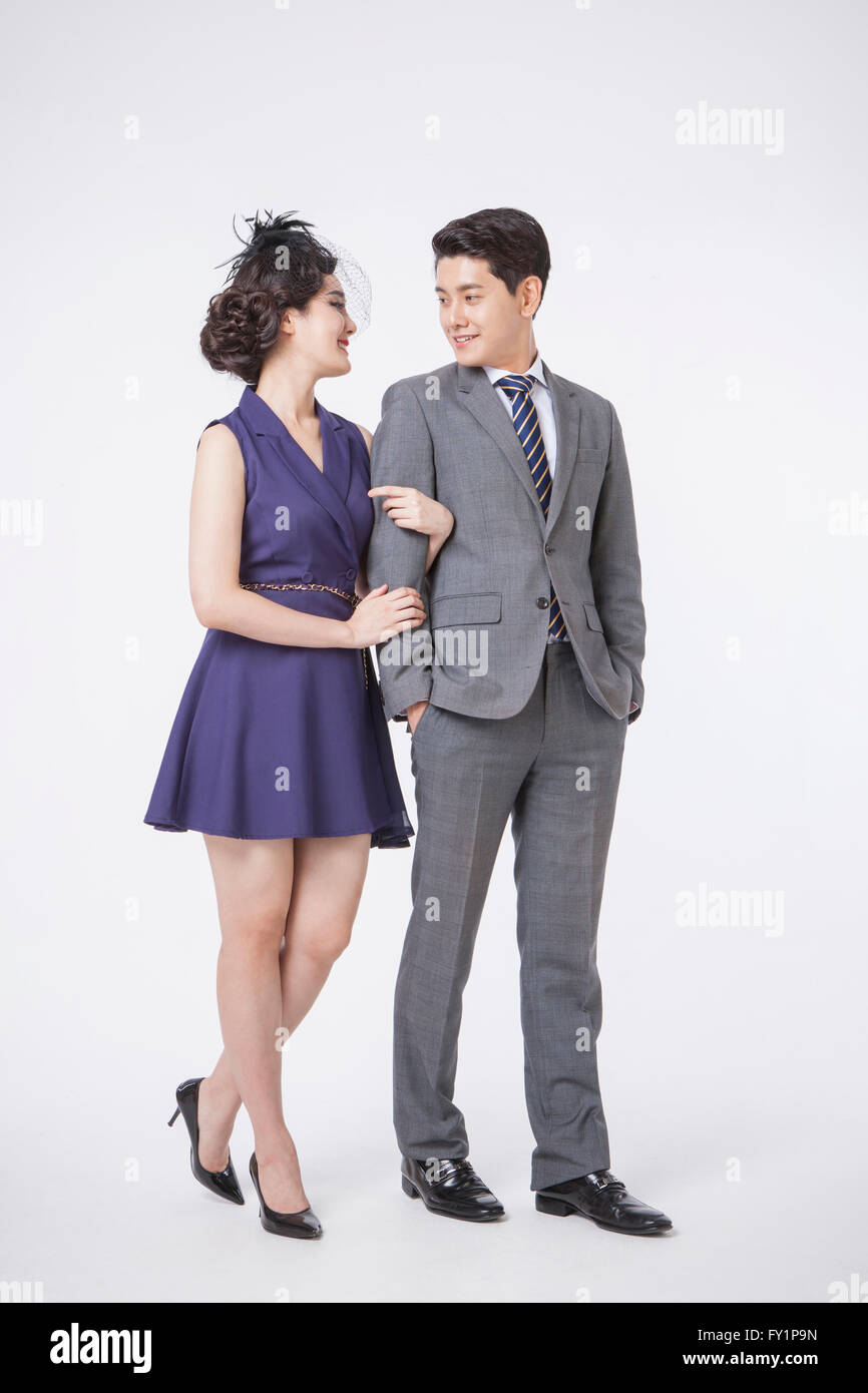 Young smiling couple in retro styles walking face to face and arm in ...