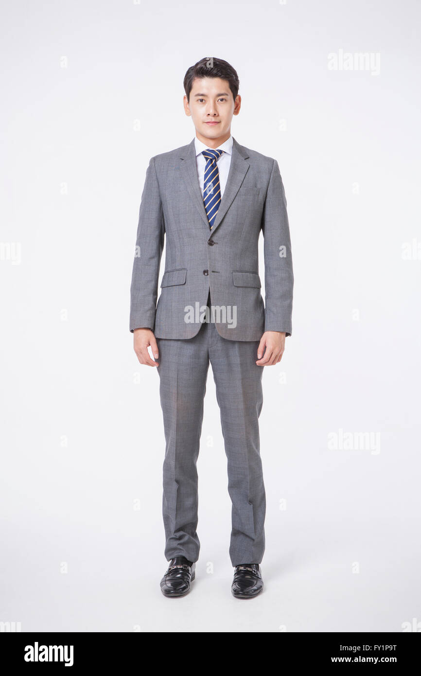 Young man in gray suit standing staring at front Stock Photo - Alamy