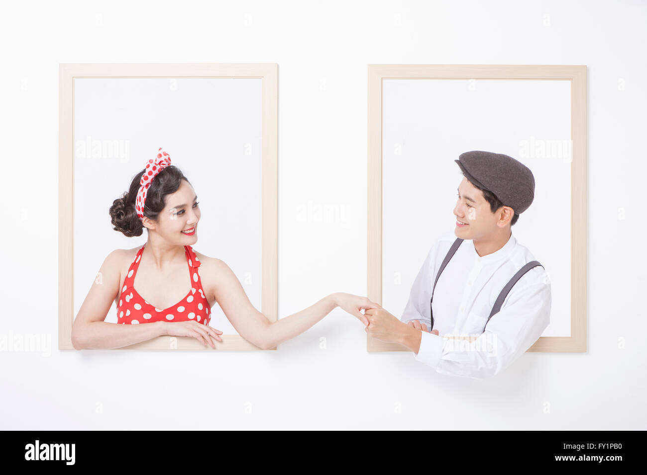 Portrait of young smiling couple in retro styles in a frame each ...