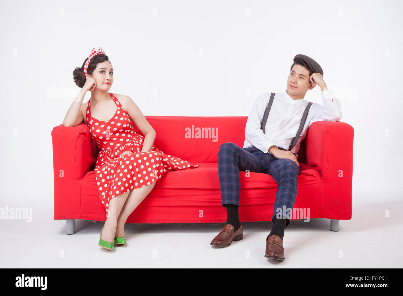 Young couple in retro styles sitting on a sofa and thinking Stock Photo ...