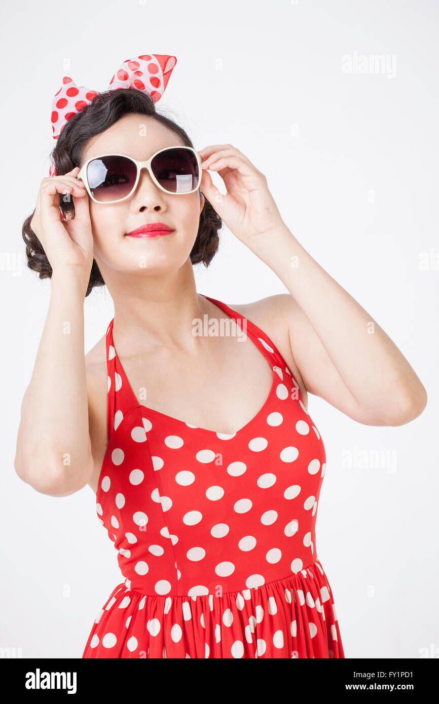 Portrait of young smiling woman in retro style wearing and touching ...