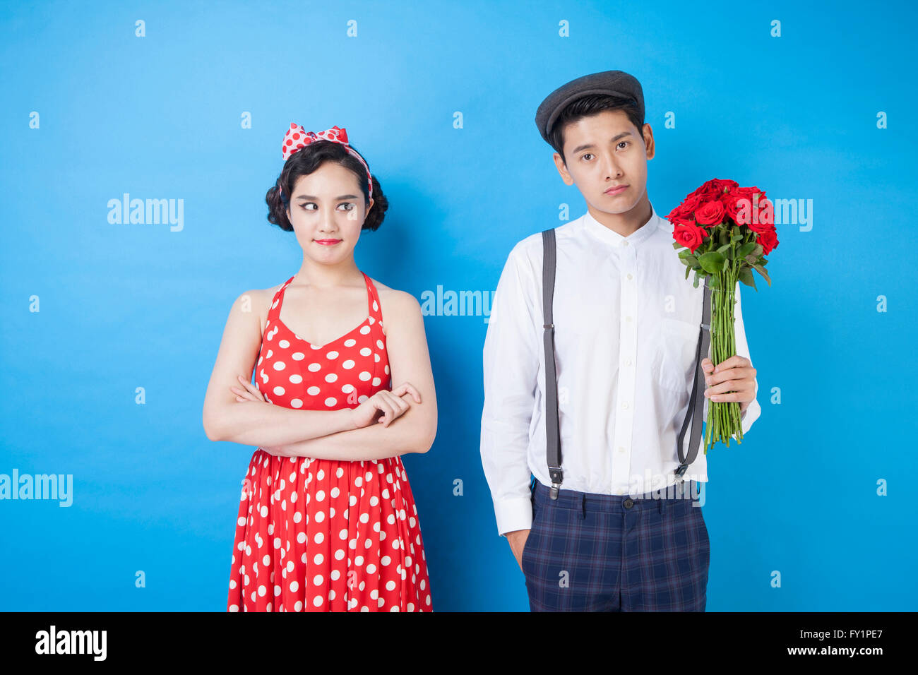 Young woman looking daggers at a young man with flowers Stock Photo - Alamy